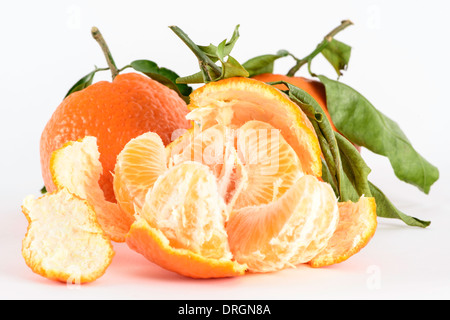 3 Satsumas with stalks and leaves, one satsuma open with satsuma ...