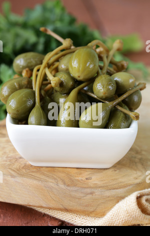 Pickled capers in the bowl on wood background Stock Photo - Alamy