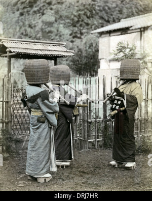 Komuso monk playing a bamboo shakuhachi flute with a woven basket on ...
