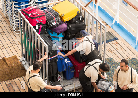 Men loading baggage crate for offloading from cruise ship Stock Photo ...