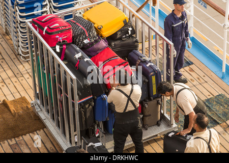 Men loading baggage crate for offloading from cruise ship Stock Photo ...