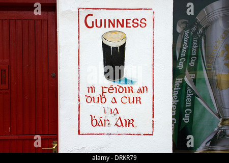 Irish pub with Guinness ad poster in both Gaelic and English, Kilkenny ...