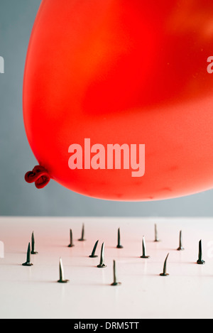 Balloon about to fall on pushpin Stock Photo - Alamy