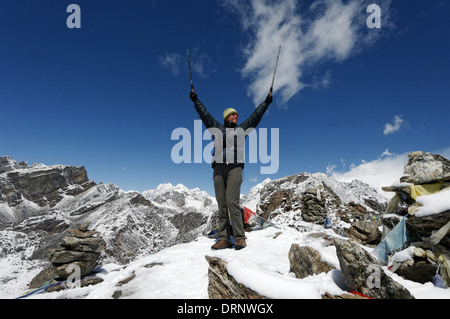 A lady trekker celebrates arriving at the summit of Gokyo Ri, Nepal ...