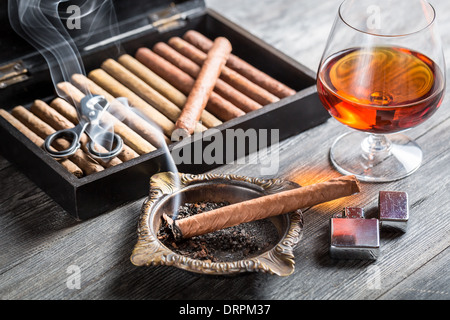 Aroma floating up from cigar and cognac in glass Stock Photo - Alamy