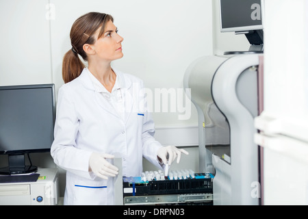 Lab technician loading blood samples for coagulation test analysis in ...