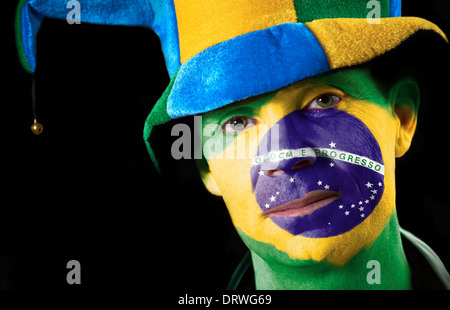 Brazilian fan with paint on his face celebrating on a blue lights ...