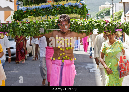Devotee of the Lord Muruga carrying the Cavadee during the Thaipoosam ...