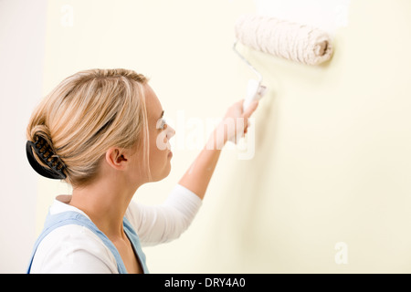 Home improvement - handywoman painting wall with roller Stock Photo - Alamy