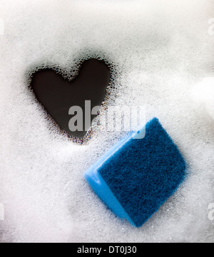 Heart shape in soap suds with green scourer Stock Photo - Alamy
