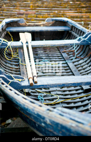 An abandoned boat with oars on the shore of a lake Stock Photo - Alamy