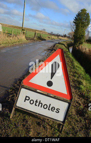 warning sign of potholes in road surface uk Stock Photo - Alamy