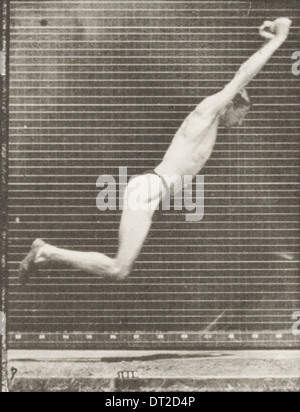 A man in a pelvis cloth performs a standing broad jump, captured in a ...