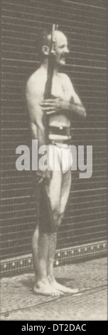 A photograph of a man wearing a pelvis cloth, positioning a bayonet ...