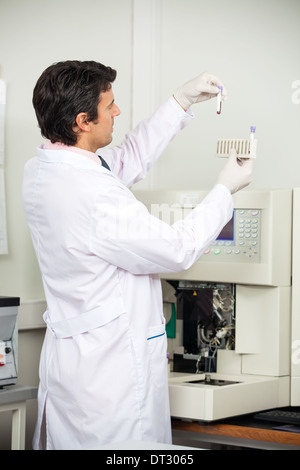 Lab tech loading samples into a chemistry analyzer Stock Photo - Alamy