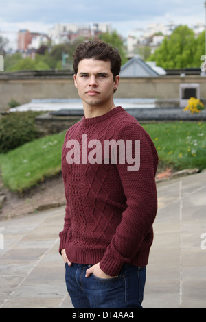 An attractive, fashionable and young male model posing outdoors on a ...