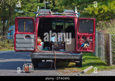 The construction van parked at roadside with open doors and tools ...