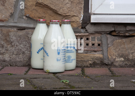 Milkman delivering milk on a doorstep Stock Photo - Alamy