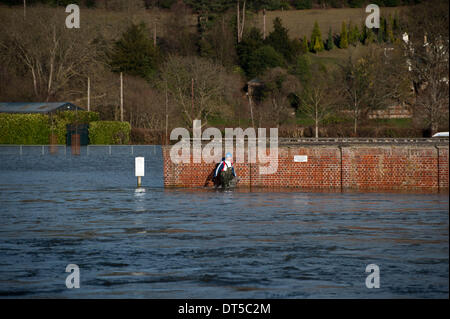 Henley, Oxfordshire, UK. 9th February 2014. . A man in waders walks ...