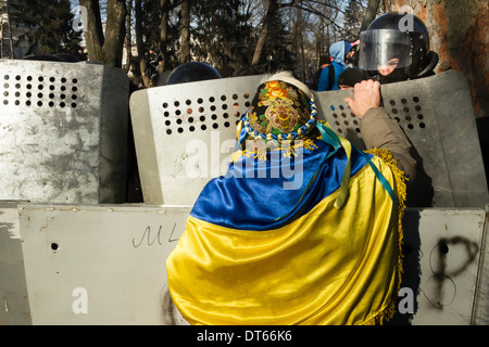 A women Euromaidan protester confronts rows of government riot police ...