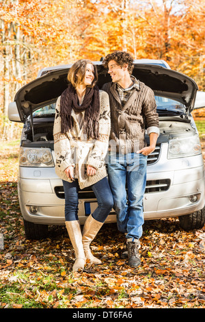 Young man leaning against his car with a bunch of flowers Stock Photo ...