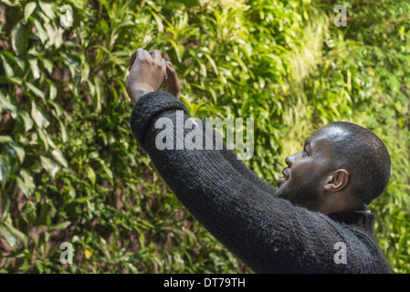 Side view of a man taking mobile photos of his girlfriend in a ...