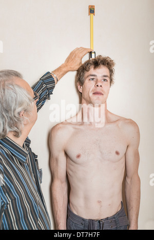 General practitioner measuring the height of a patient during medical ...