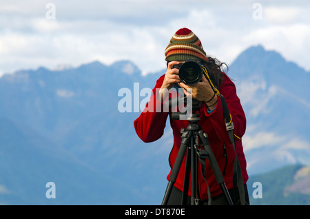Professional photographer work on mountain peak. Nature photographer ...