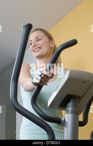 Woman exercising on an exercise bike Stock Photo - Alamy