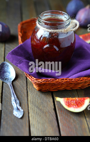 Glass jar with tasty fig jam isolated on white background, closeup ...