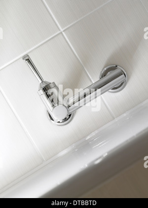 Silver chrome tap in bathroom with marble fossil tiled walls Stock ...
