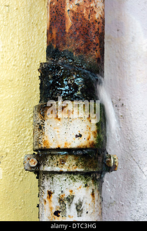 Old rusty pipe with leak and water spraying out under pressure leaky ...