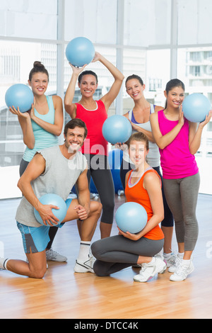 Fit young people with balls in exercise room Stock Photo - Alamy