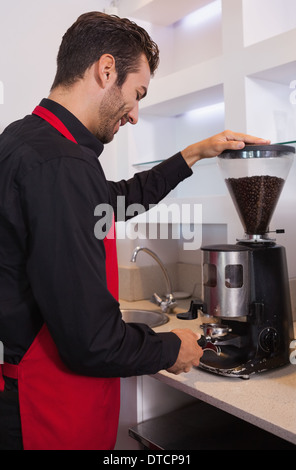Happy barista grinding coffee beans Stock Photo - Alamy