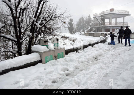 Mussoorie, India. 15th Feb, 2014. A man walks past a snow-covered road ...