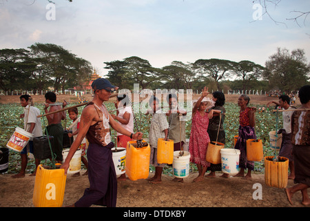 FILE - People fill water containers at a free distribution point amid ...