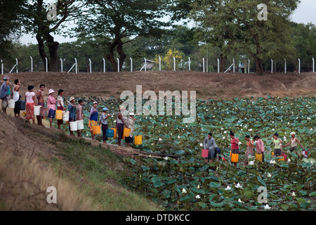 FILE - People fill water containers at a free distribution point amid ...