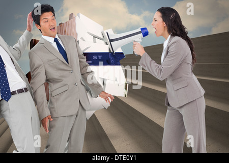 Composite image of businesswoman with megaphone yelling at colleagues ...