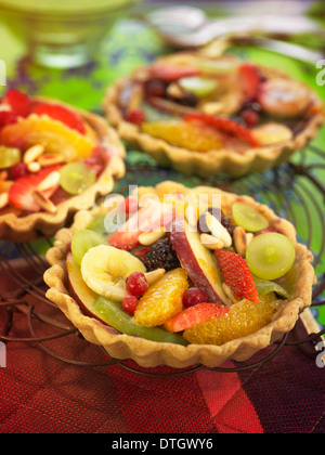 Fruit tartlet. Strawberry, kiwi and banana tartlet on a dark background ...
