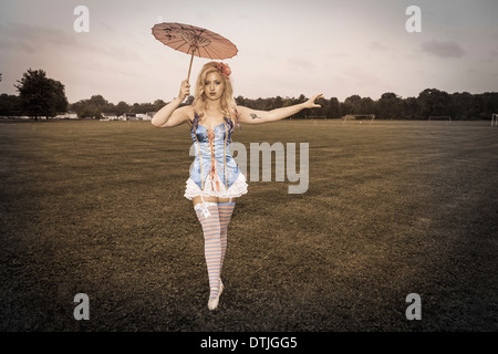 A young woman wearing a laced basque and frilly bloomers striped ...