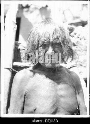 A photograph of an elderly Hopi Indian man outside, smoking a cigarette ...