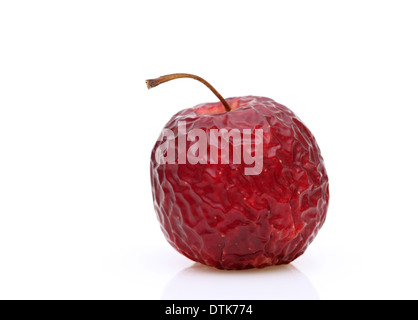 Red dry rotten unhealthy apple on a table. Unhealthy unhygienic fruit ...