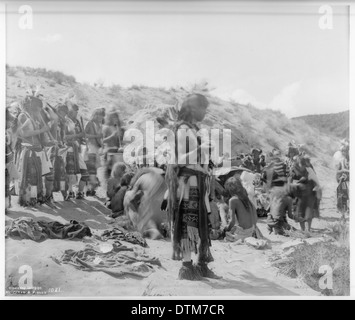 Eight Hopi Indian flute players are seen standing on the side of a hill ...