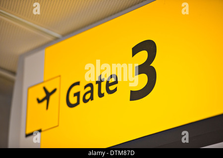 Yellow illuminated sign at airport with gate number for departing ...