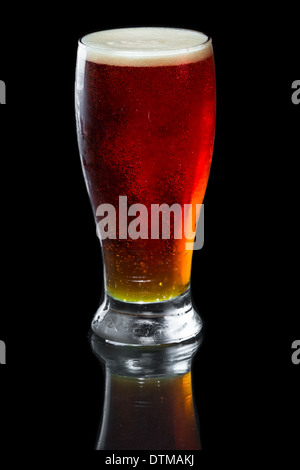 cold refreshing beer served in a cold glass isolated on a black ...