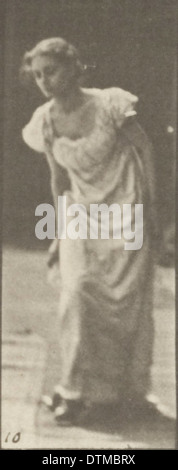 A woman in a long dress is stooping and lifting a handkerchief ...