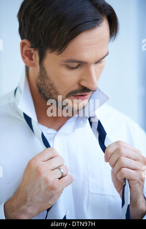 woman tying tie on handsome businessman in black suit isolated on grey ...