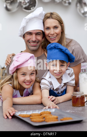 Happy children and parents eating biscuits Stock Photo - Alamy