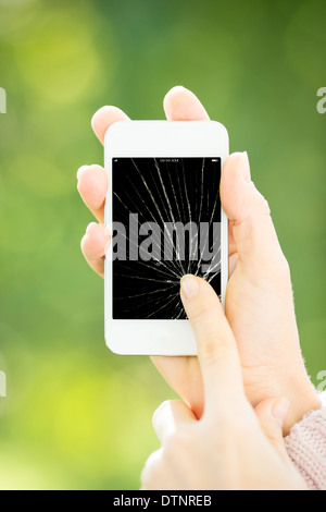 Woman holding a smartphone with cracked screen, smartphone repair ...