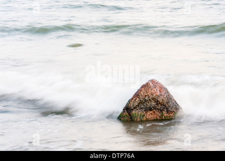 Single stone or rock in a blurry sea Stock Photo - Alamy